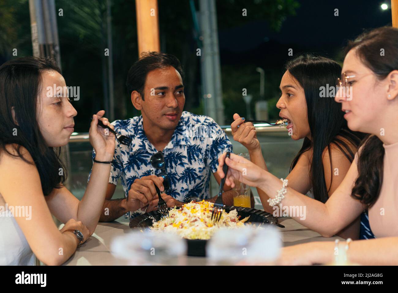 Group of friends eating fast food in a restaurant. Cheerful young ...