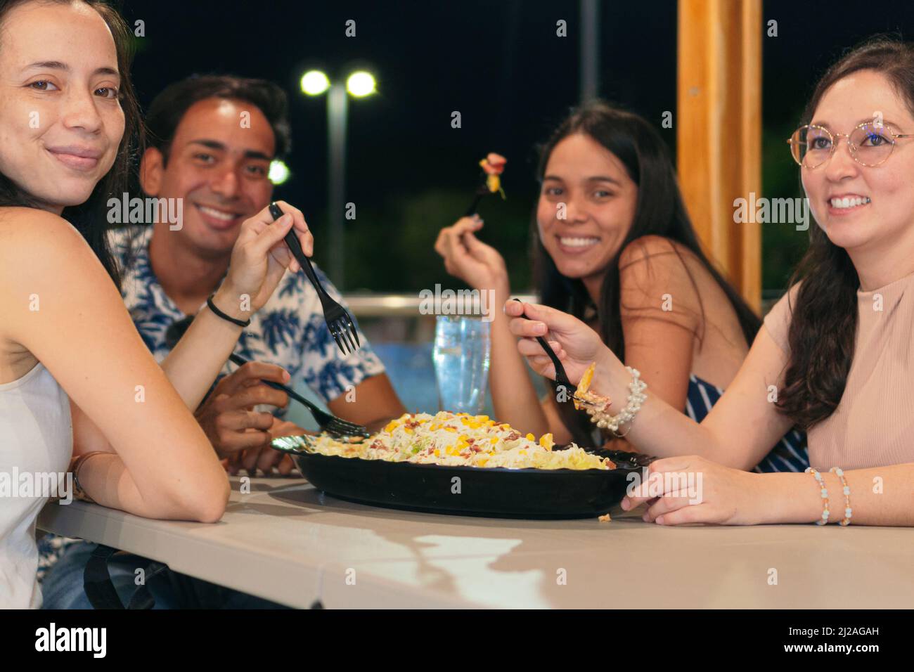 Group of friends eating fast food in a restaurant. Cheerful young ...