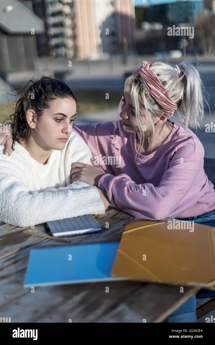 Young woman teenager embracing to calm her sad best friends from ...