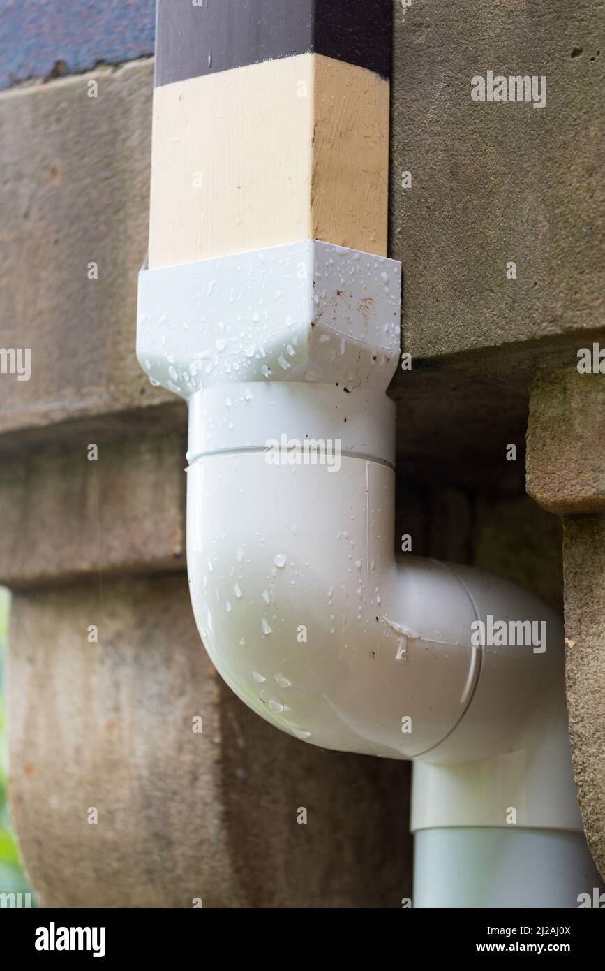 White unplasticized polyvinyl chloride uPVC downpipe (downspout) and ...