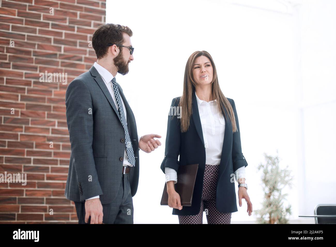 two employees talking standing in the office Stock Photo - Alamy