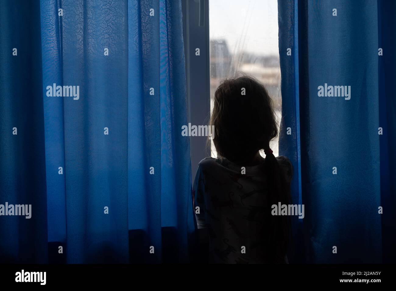 Little sad girl near window. Abuse of children concept Stock Photo - Alamy
