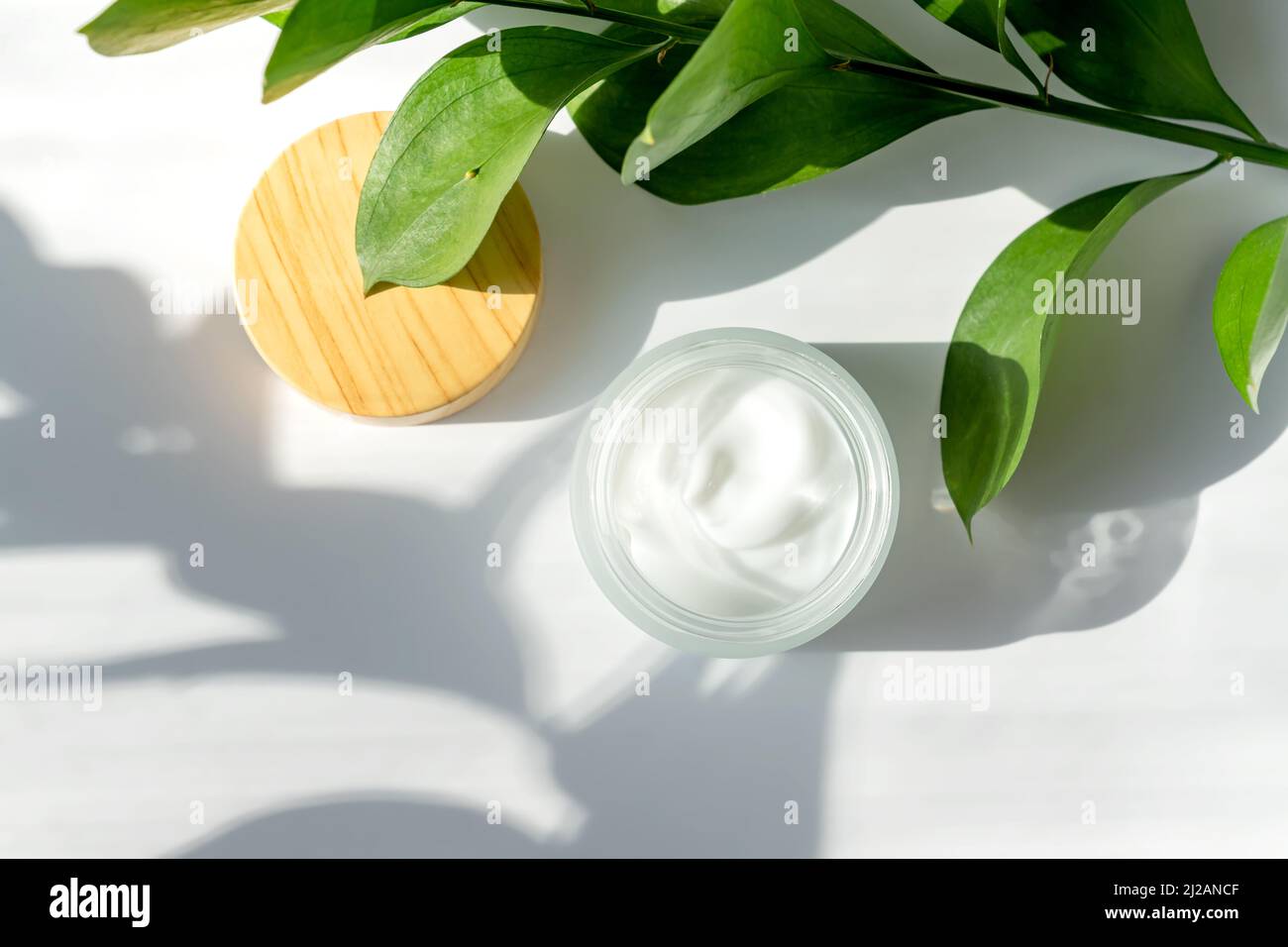 Top view of open jar with collagen firming anti age face cream on white ...