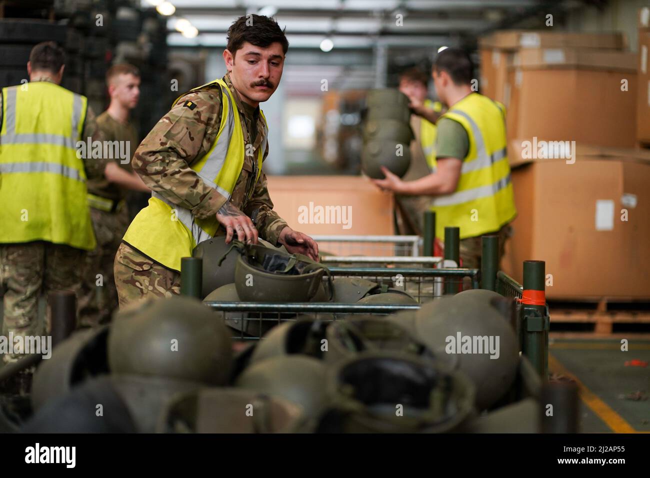 Members of the military pack thousands of surplus helmets donated by ...