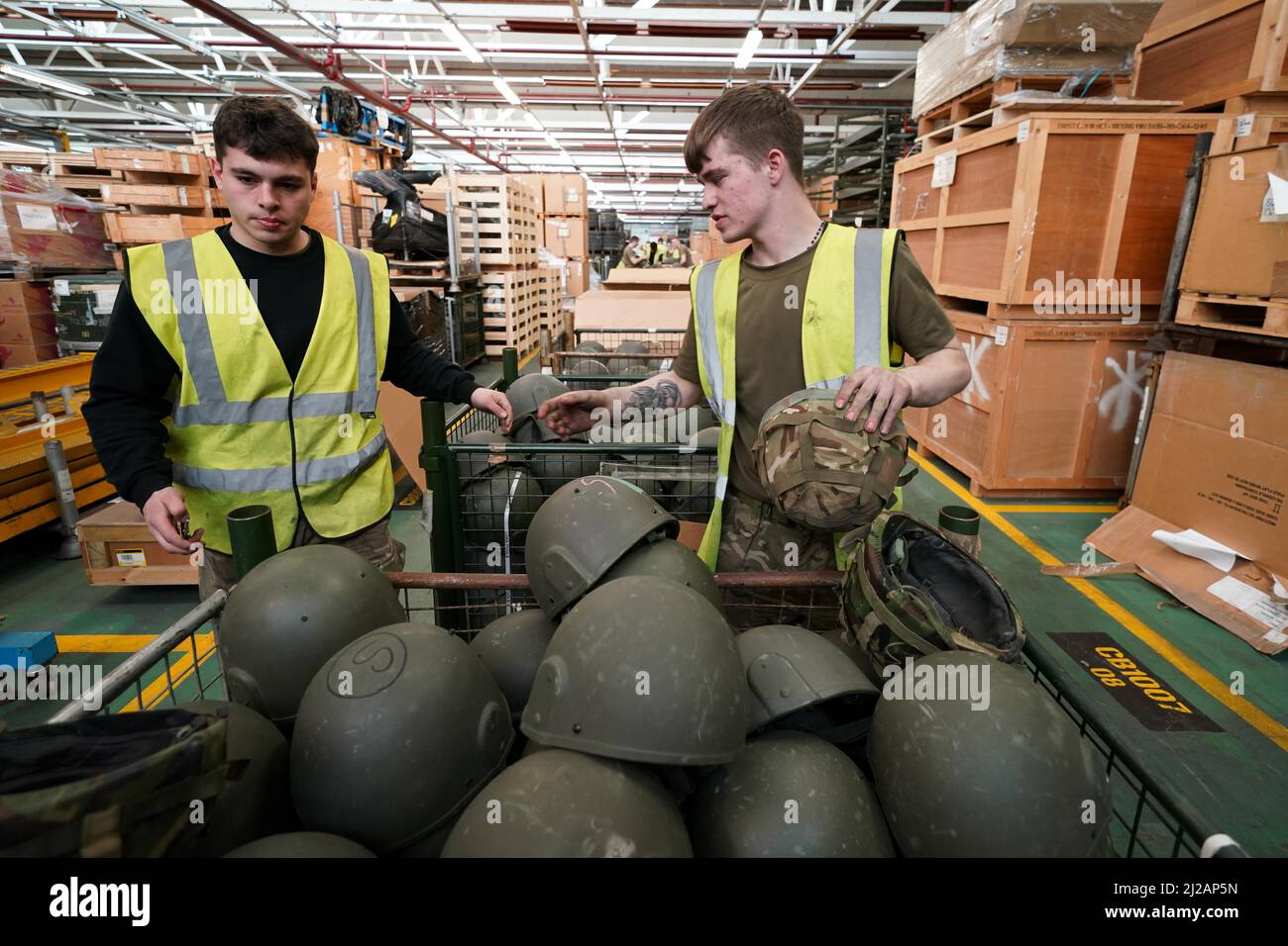 Members of the military pack thousands of surplus helmets donated by ...