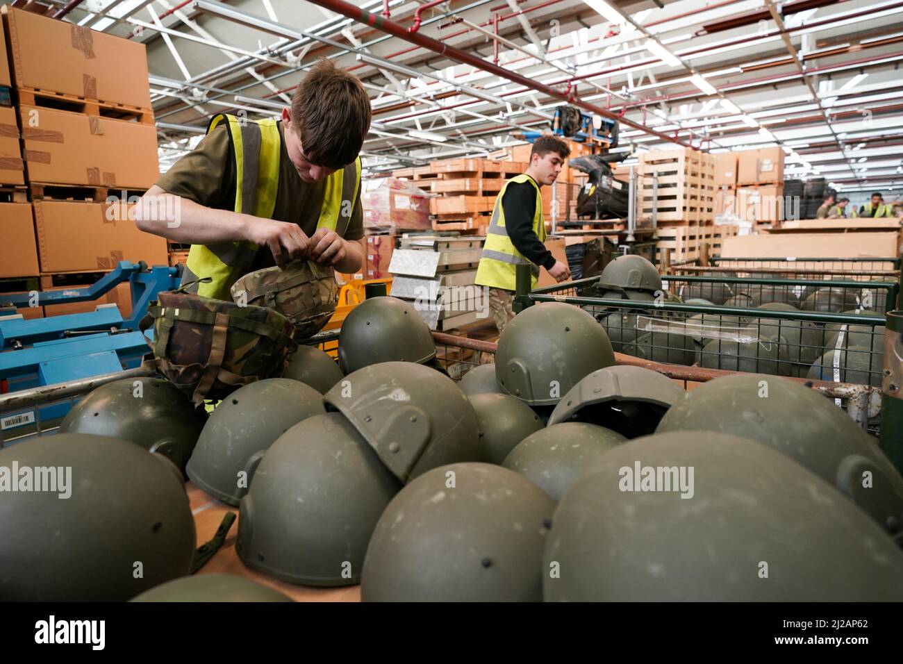 Members of the military pack thousands of surplus helmets donated by ...