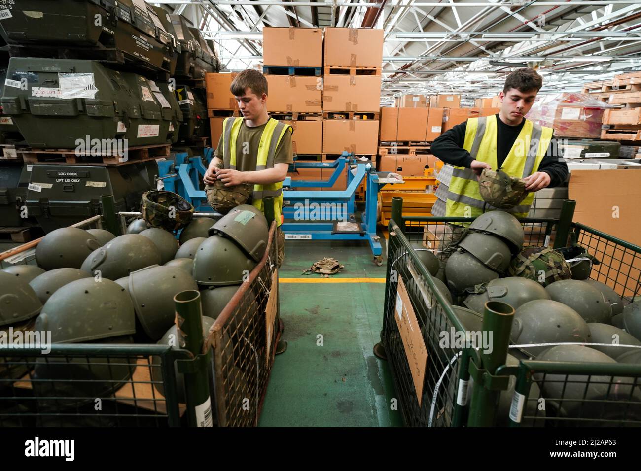 Members of the military pack thousands of surplus helmets donated by ...