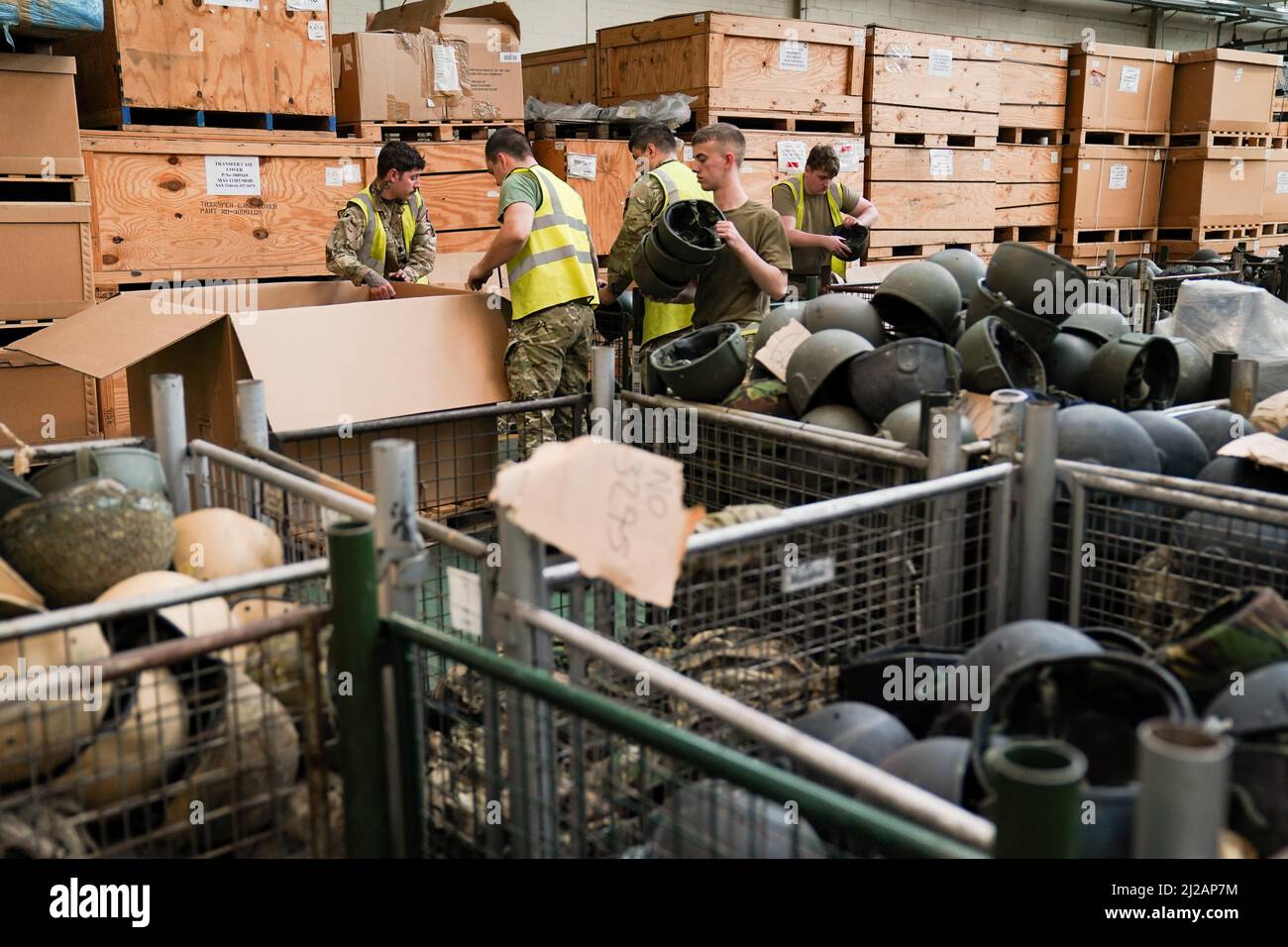 Members of the military pack thousands of surplus helmets donated by ...