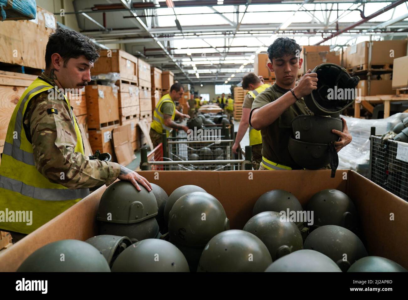 Members of the military pack thousands of surplus helmets donated by ...