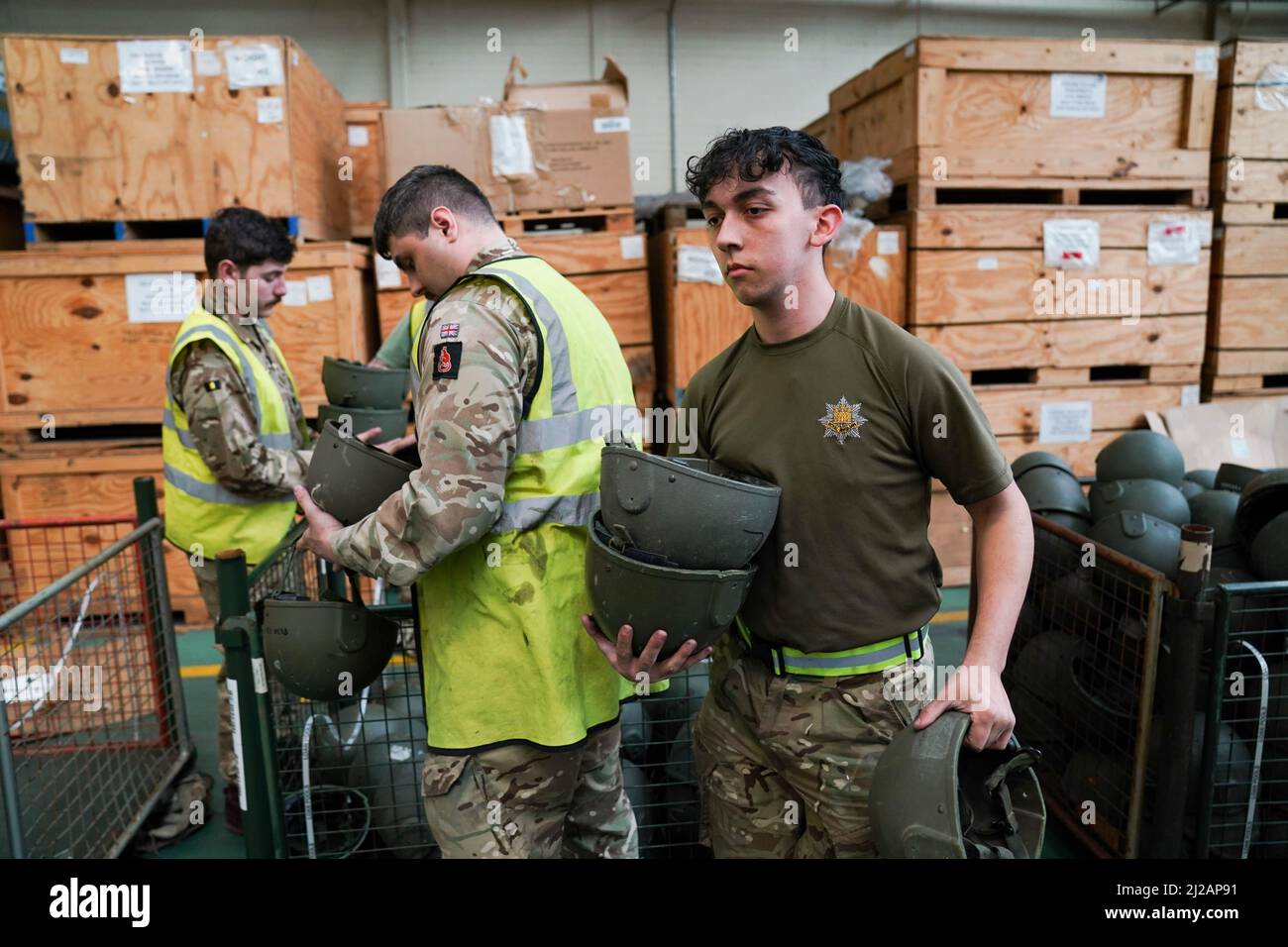 Members of the military pack thousands of surplus helmets donated by ...