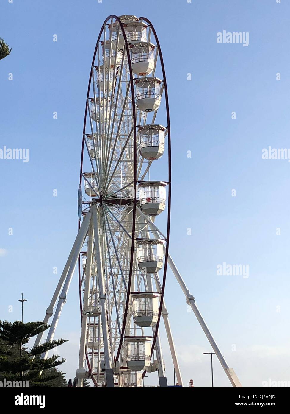 large white round giant ferris wheel with clear blue sky side angle ...