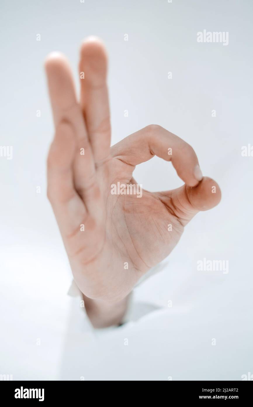 close up.male hand breaking through the paper wall and showing OK Stock ...