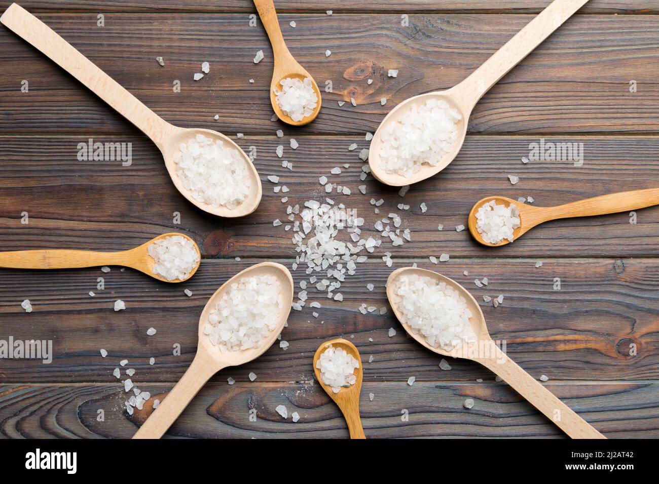 salt on many wooden spoon on wood background. Spoons with different ...