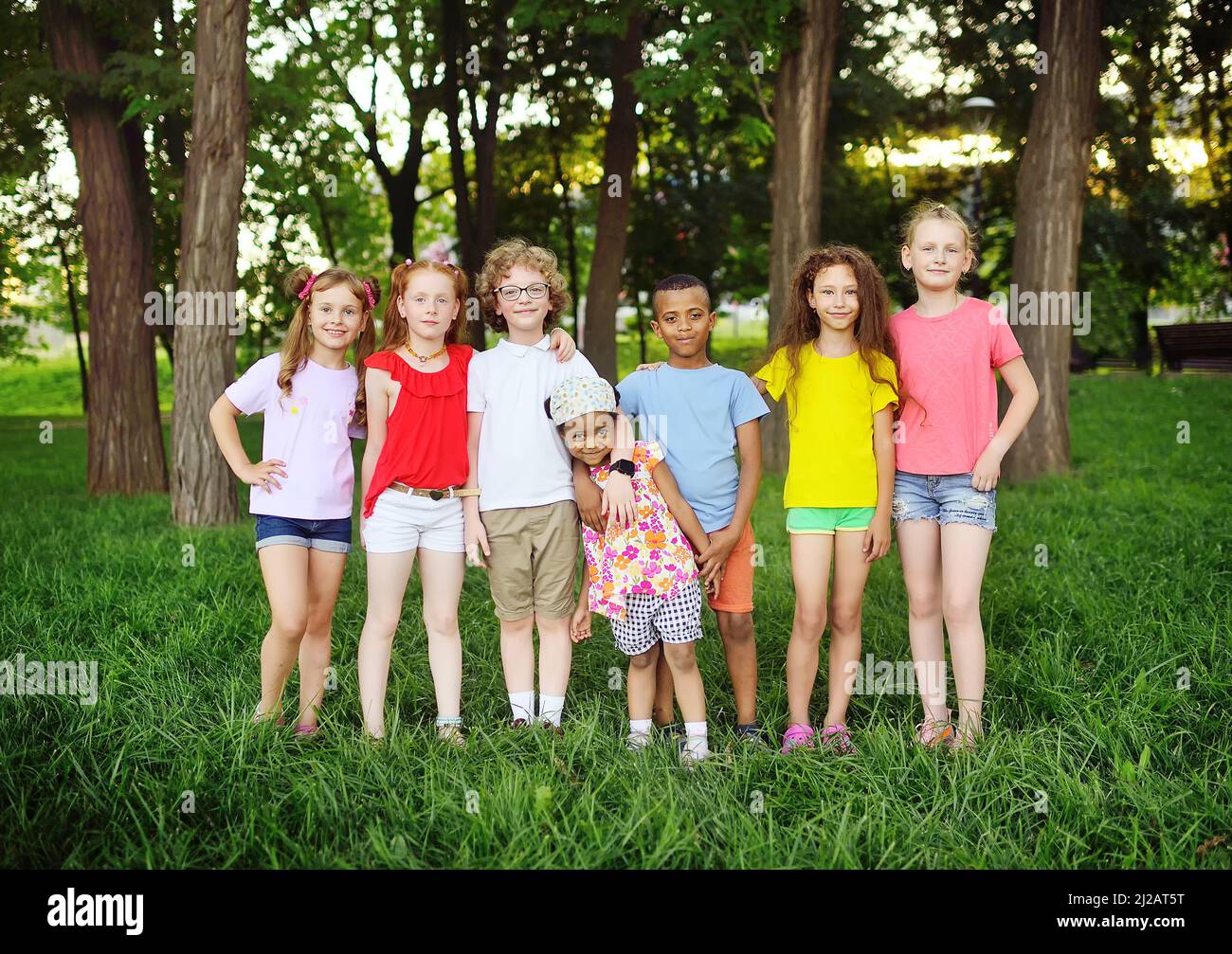 group of preschoolers of different races hug and smile against the ...