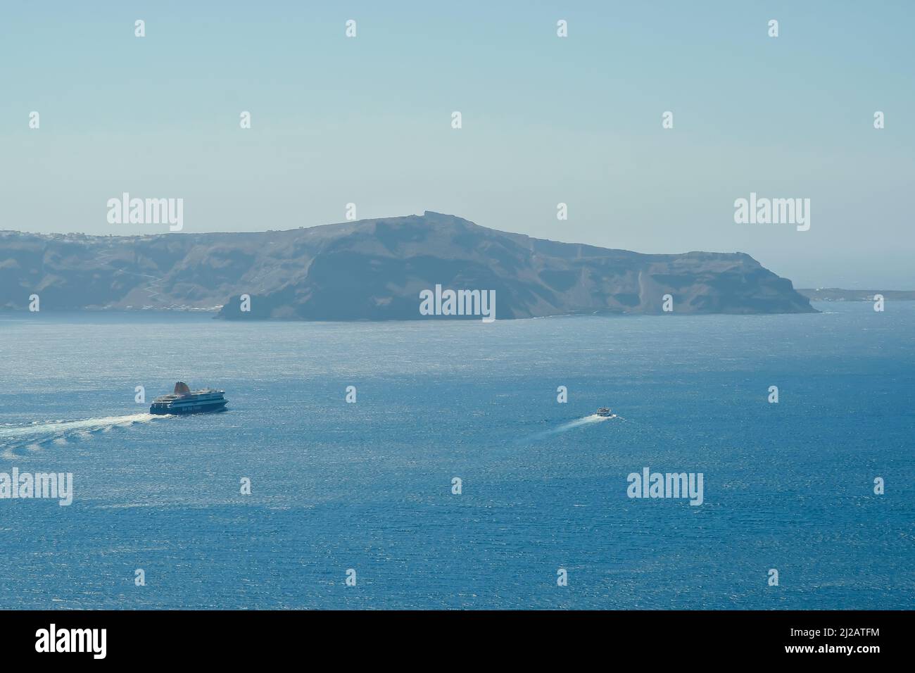 Santorini, Greece - May 10, 2021 - A bigger ferry boat and a smaller ...