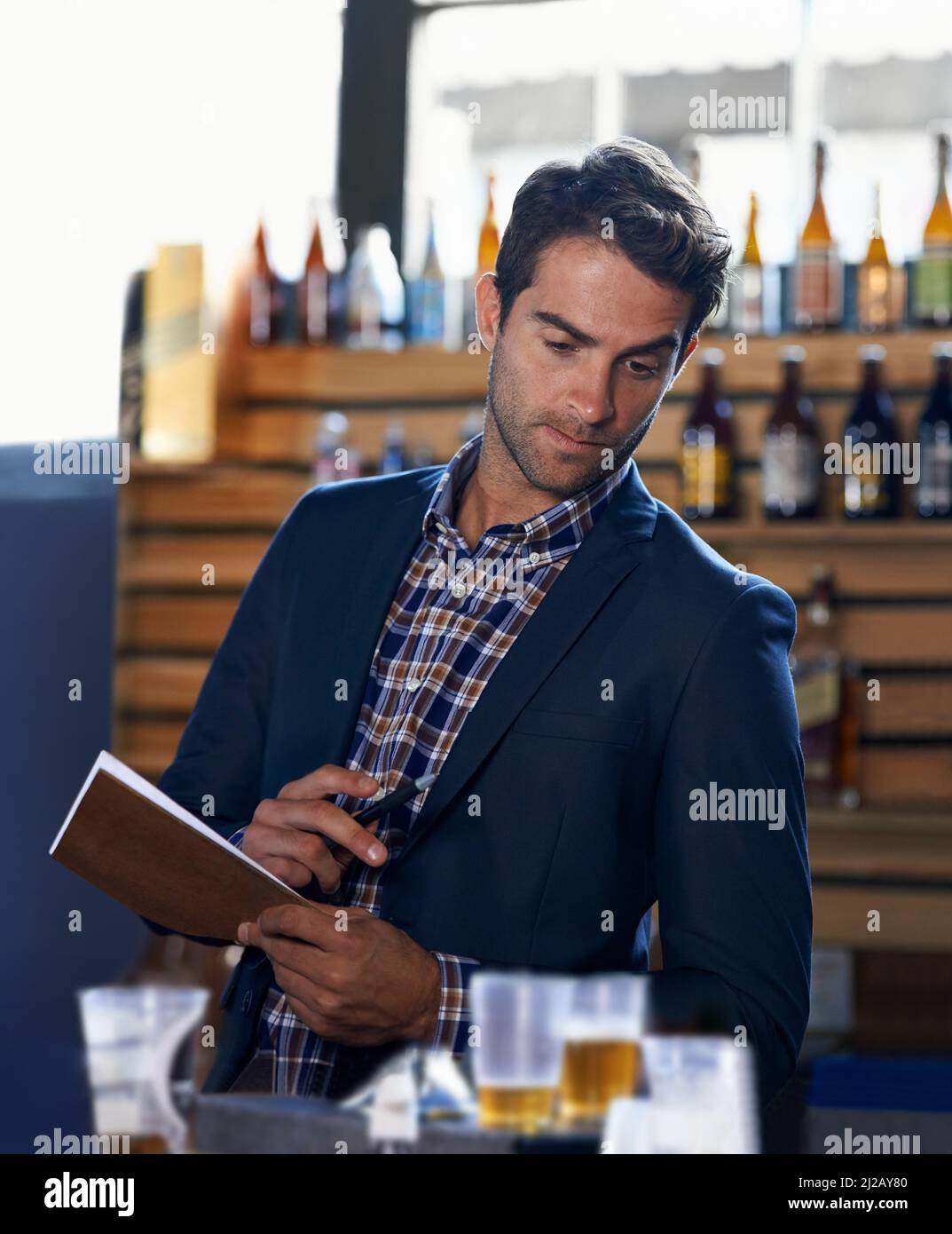 Calculating the consumption. Shot of a handsome young man doing stock ...