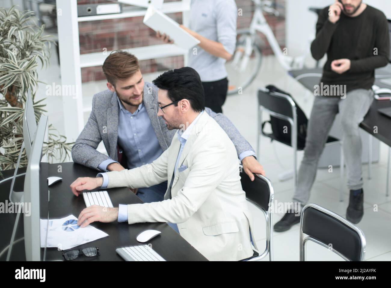 employee talking on a mobile while sitting on office Desk Stock Photo ...
