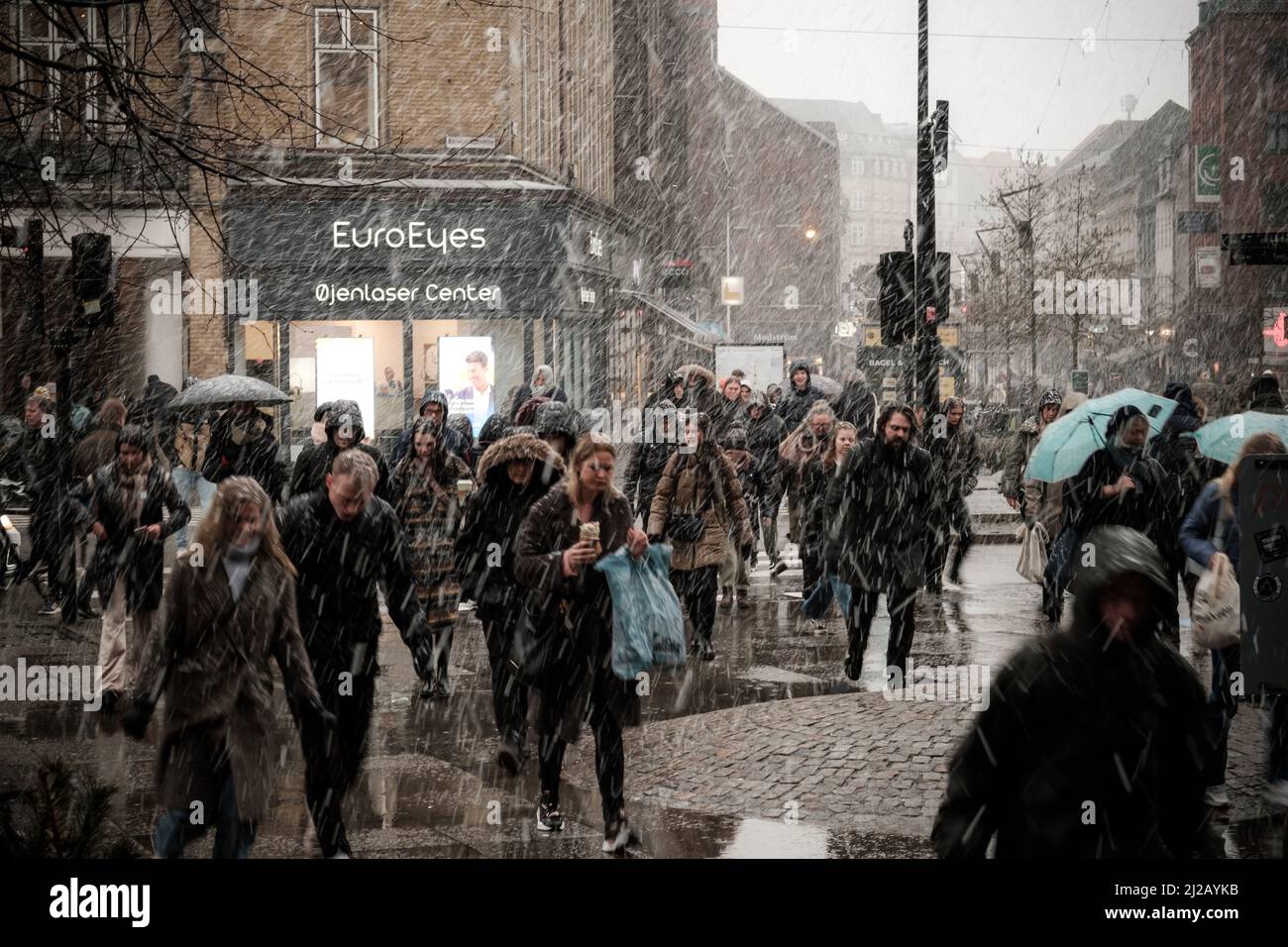 Commuters rush in snow and rain to the central train station in Aarhus ...