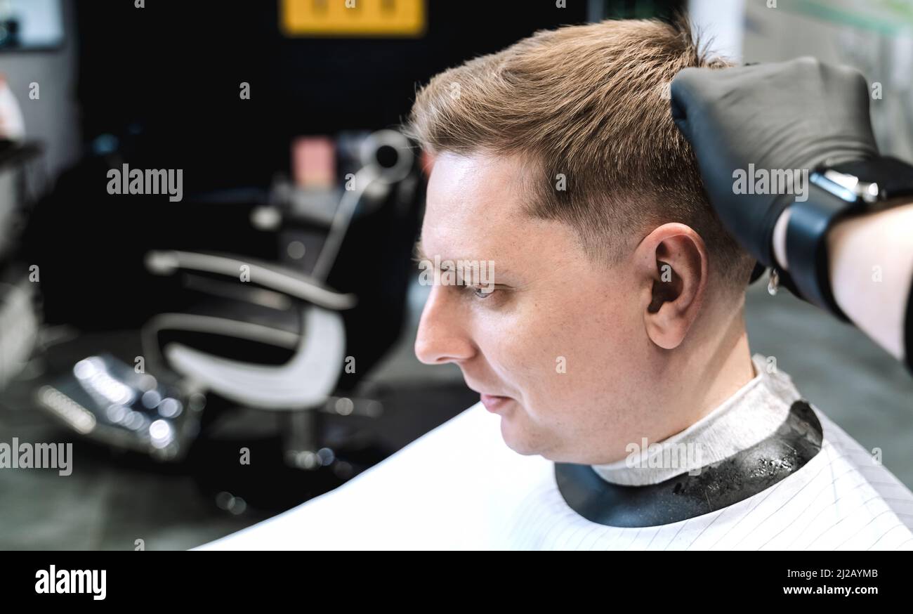 Visit to barbershop. Stylish man makes fashionable haircut. Barber ...