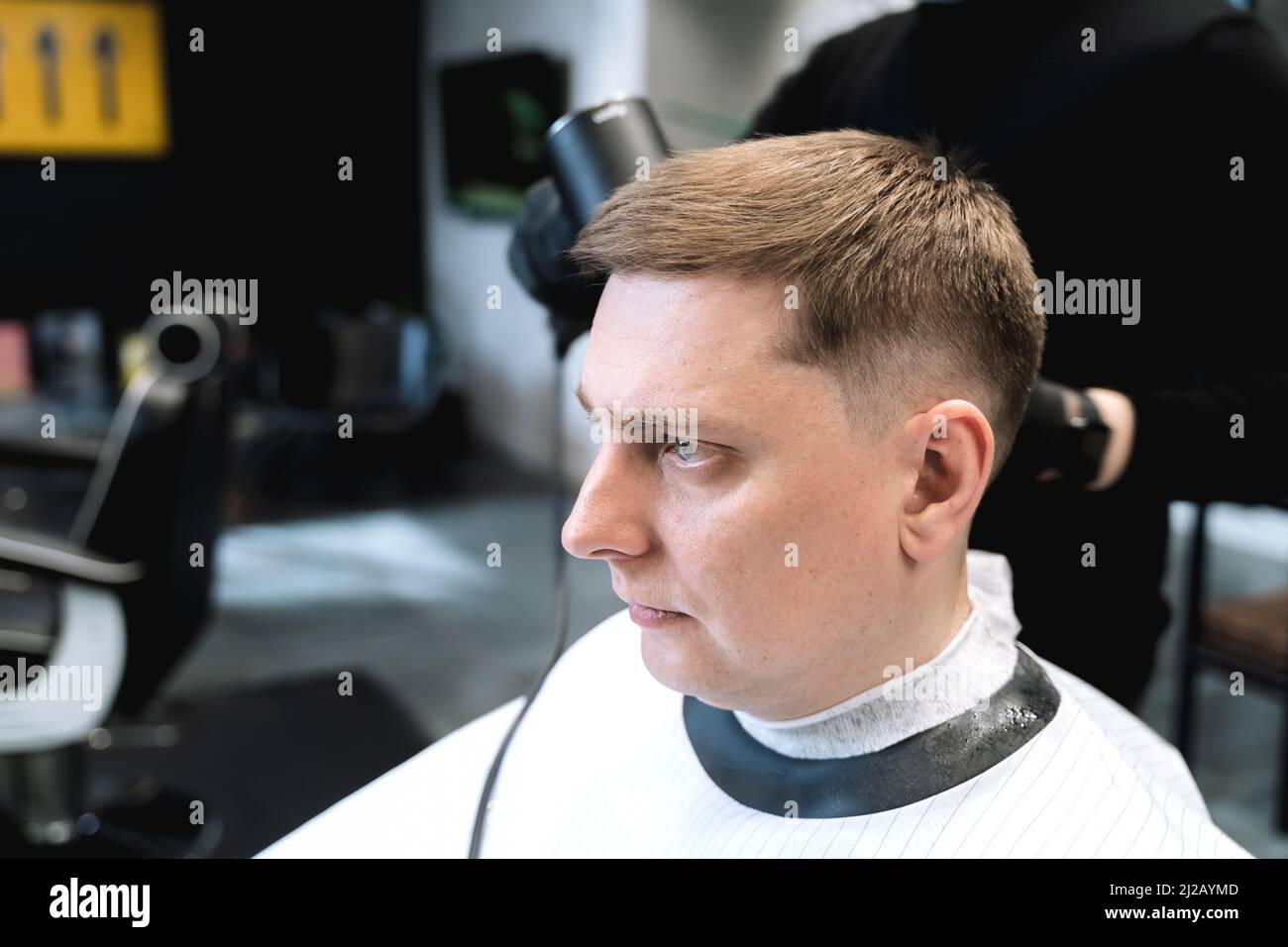 Visit to barbershop. Stylish man makes fashionable haircut. Barber ...
