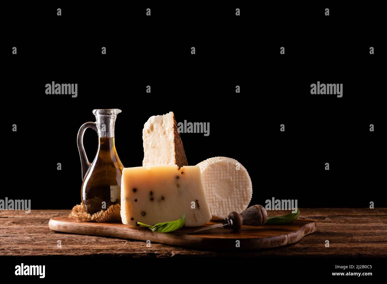Various Italian cheeses including, olive oil isolated on black ...