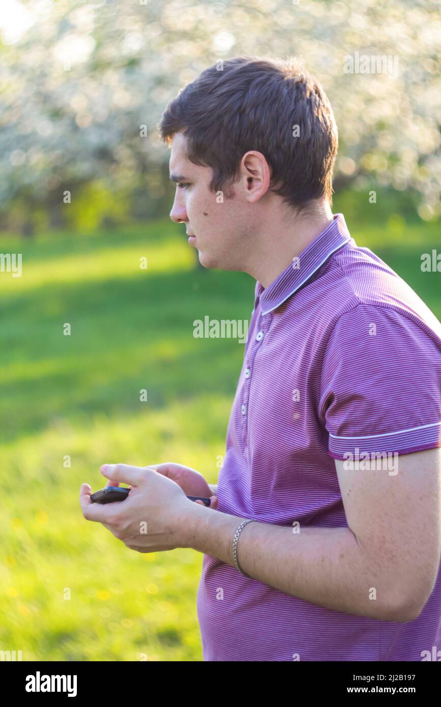 Defocus pleasant cheerful handsome young man holding phone. Profile ...