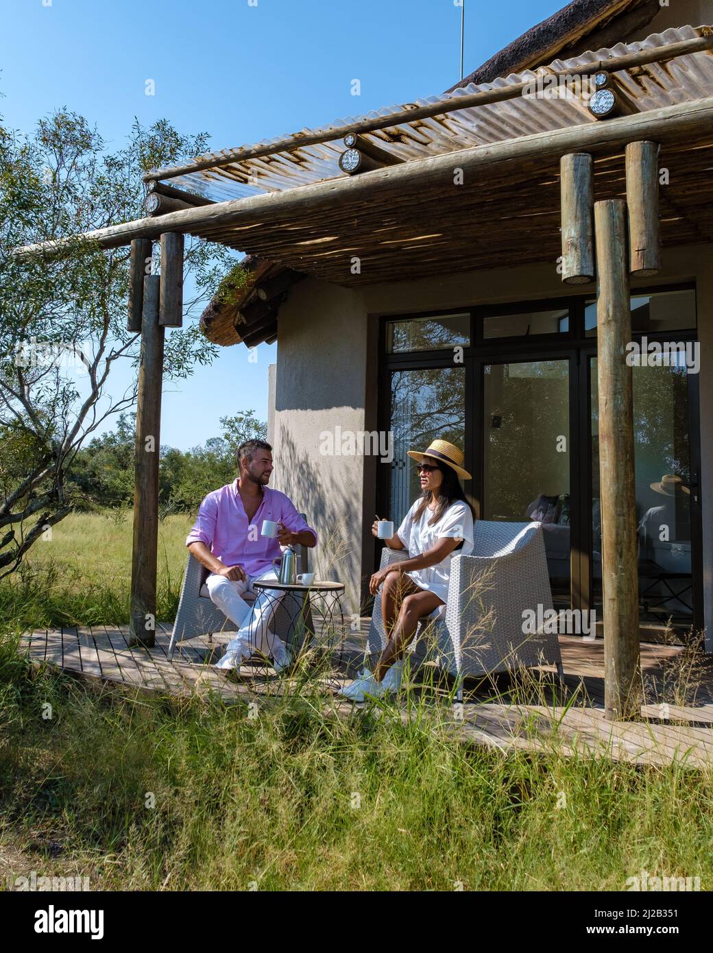 men and women drinking coffee in the morning in front of their lodge ...