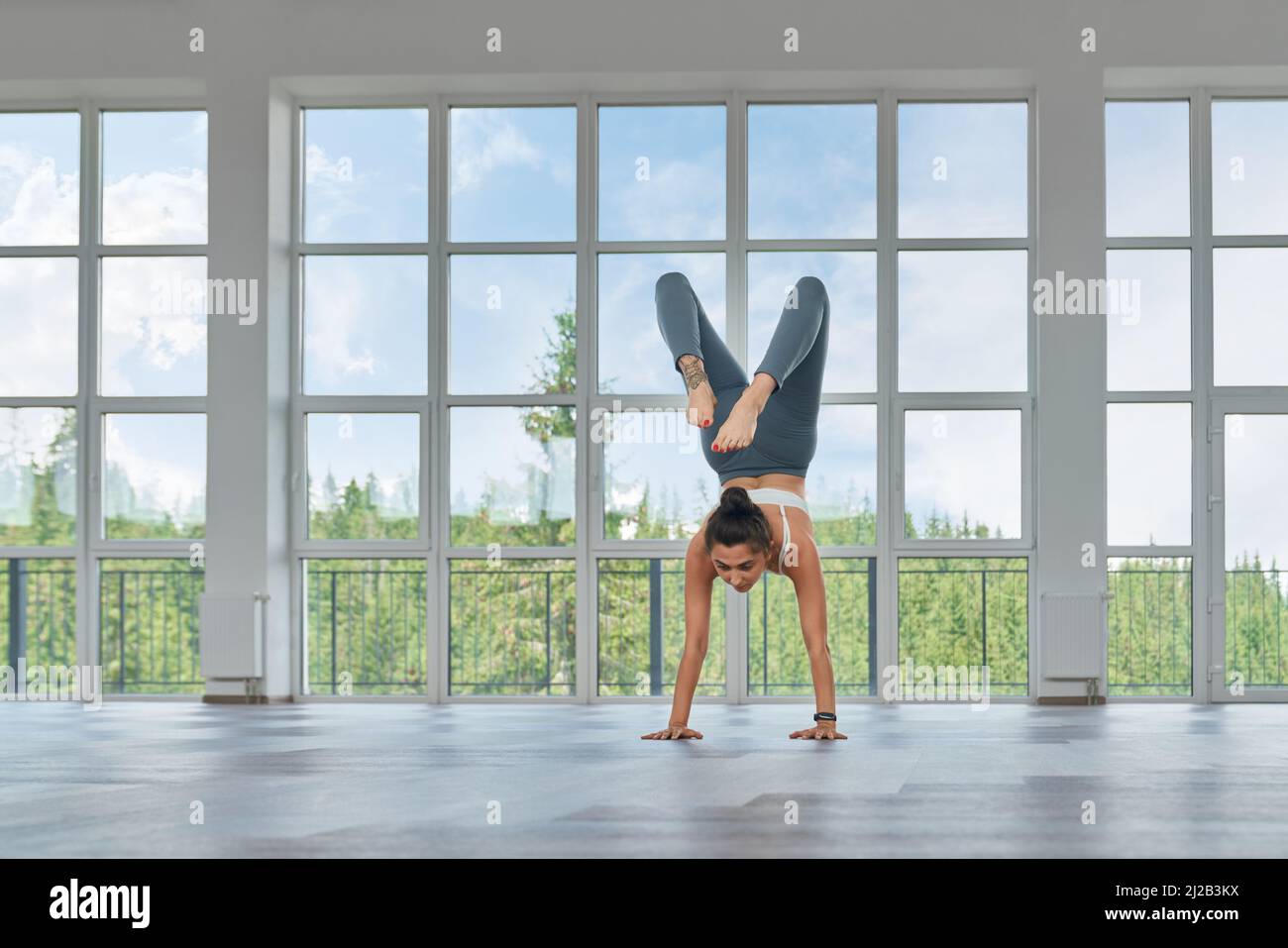 Strong woman in sport clothes practising gymnastic exercises for ...