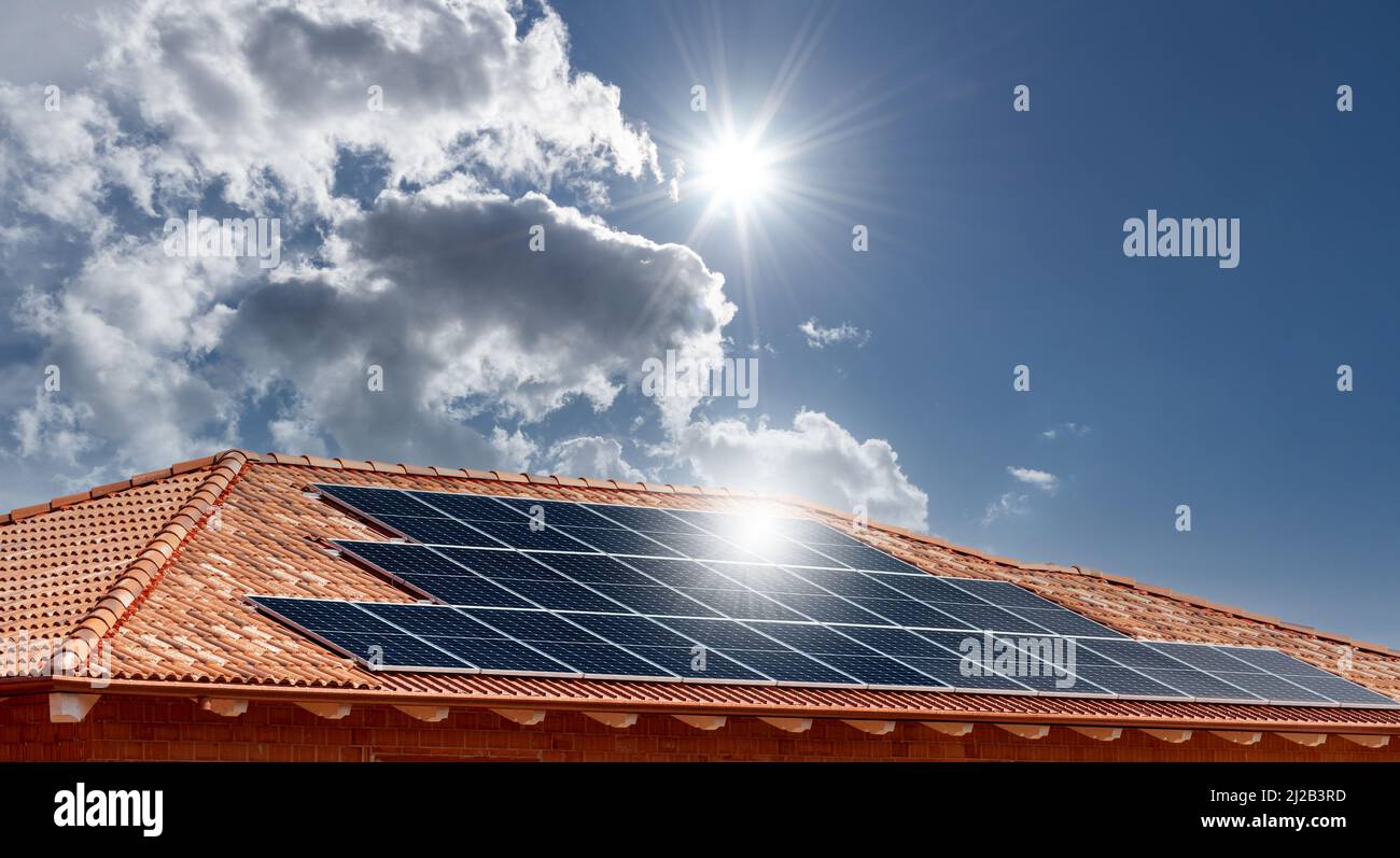 Roof with solar panels on blue sky with reflecting sun rays Stock Photo ...