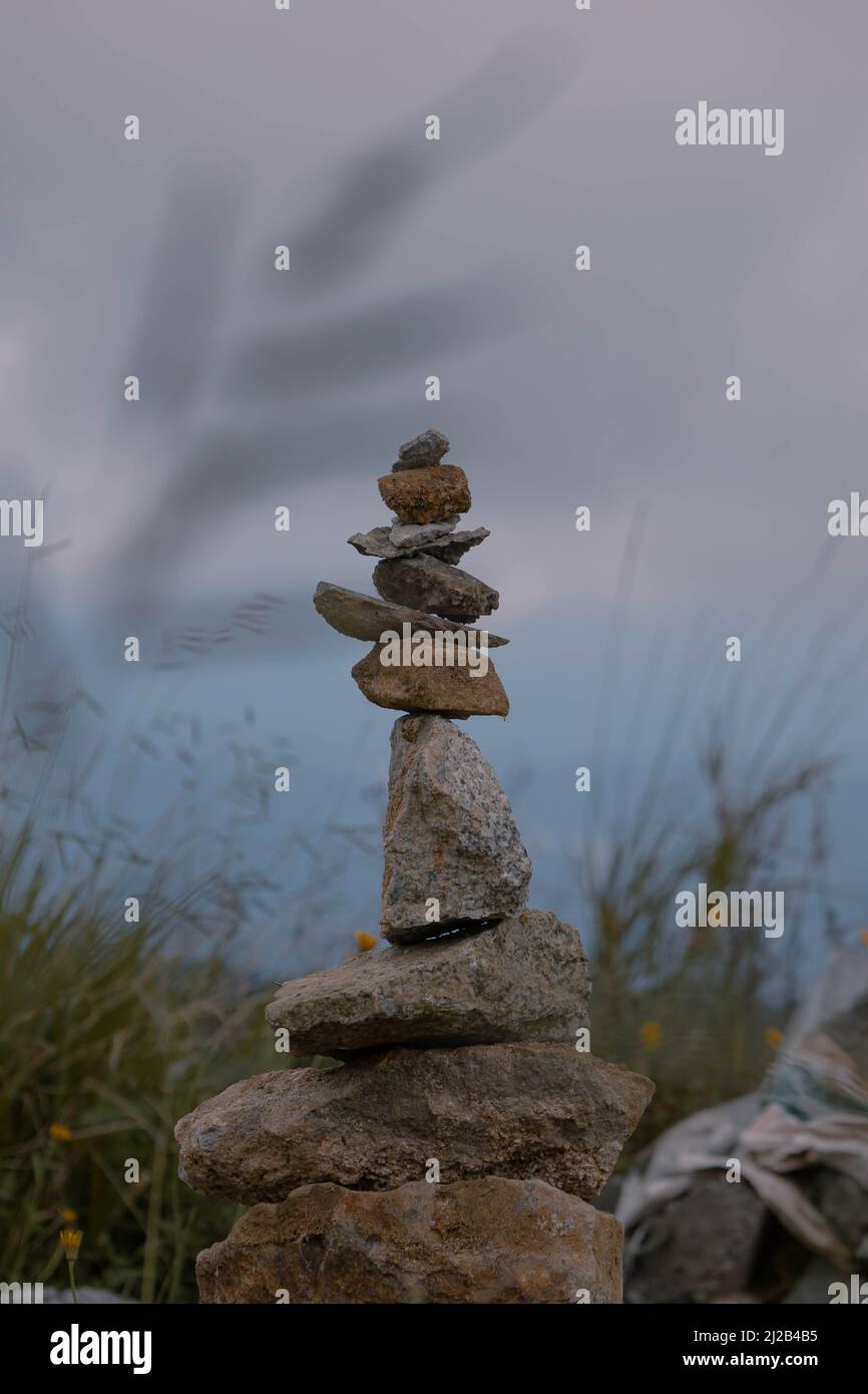 low angle shot of a balanced rock on top of each other with grass ...