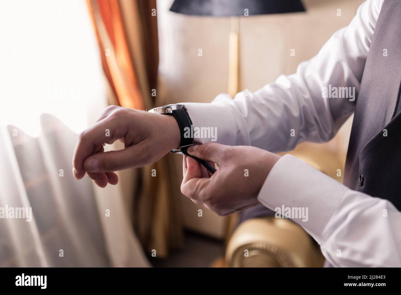 a man putting a watch on his hand Stock Photo - Alamy