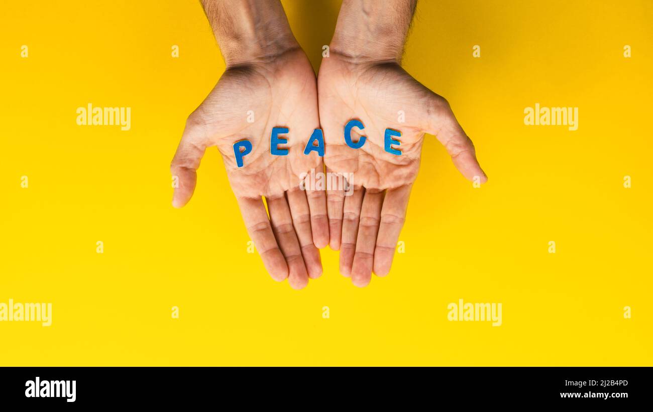 man holding a peace inscription in the colors of the ukrainian flag ...