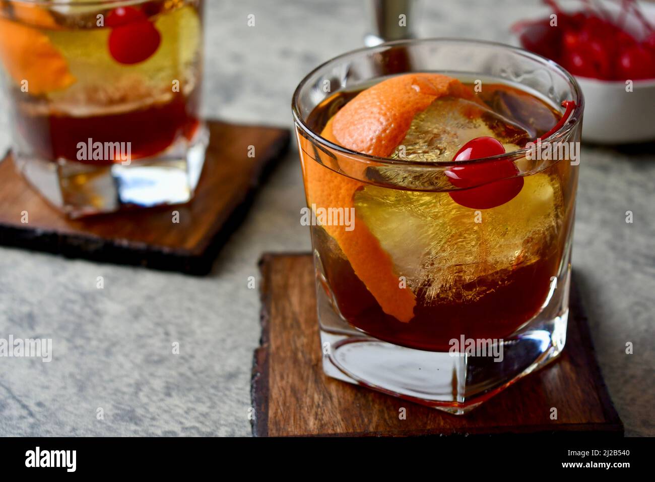 Old fashioned cocktail with orange peel garnish and maraschino cherry ...