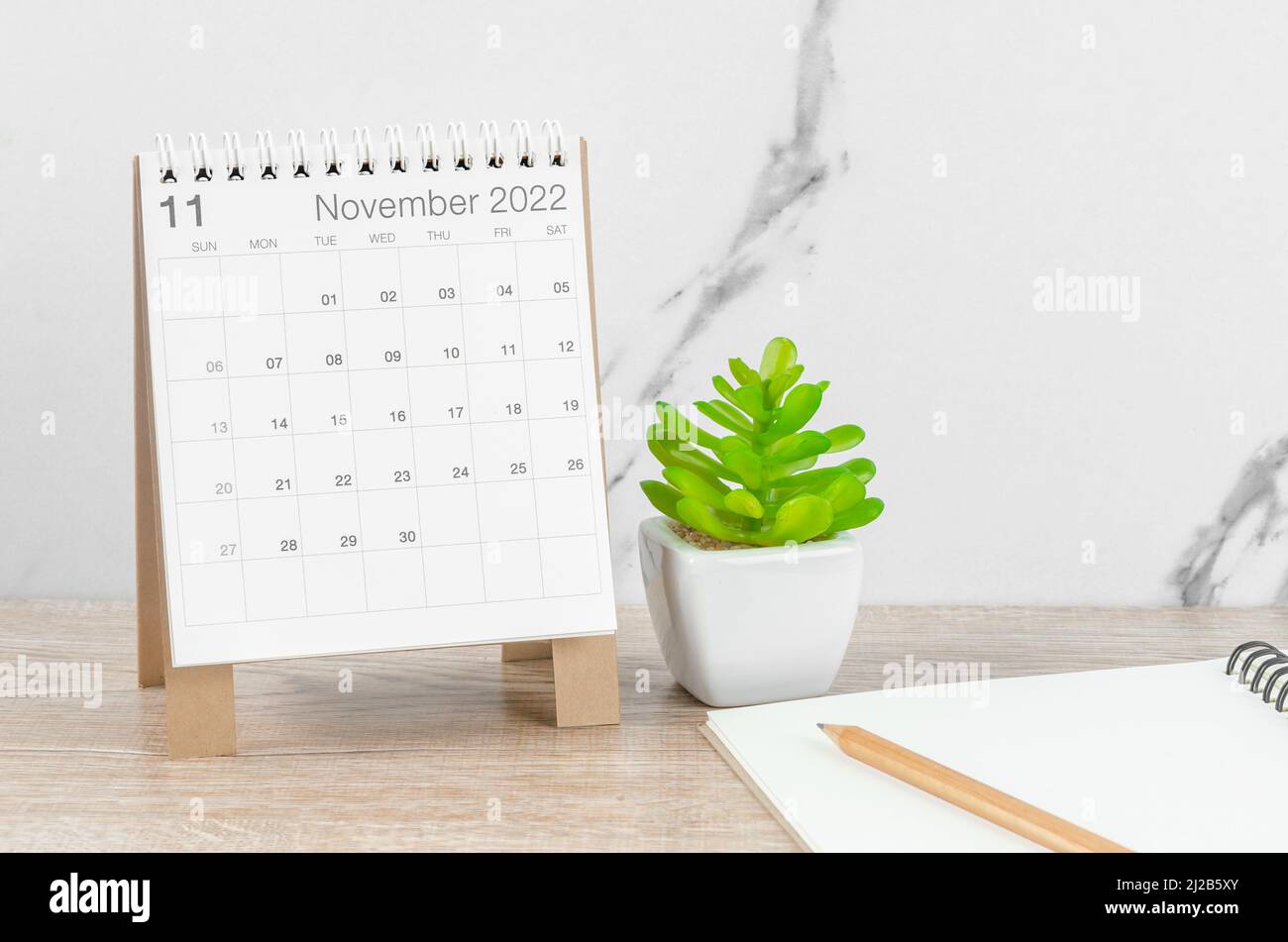 The November 2022 desk calendar with plant on wooden table Stock Photo ...