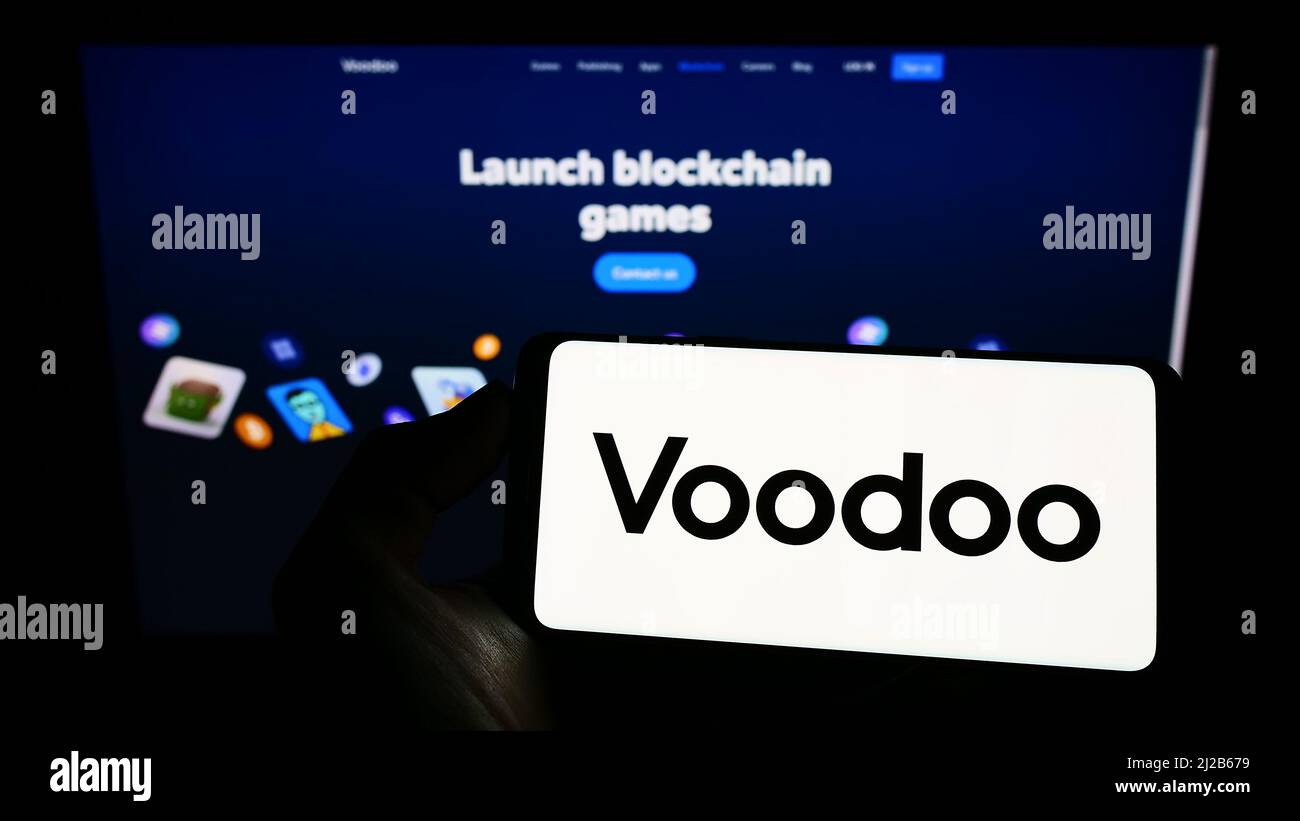 Person holding cellphone with logo of French video games company Voodoo ...