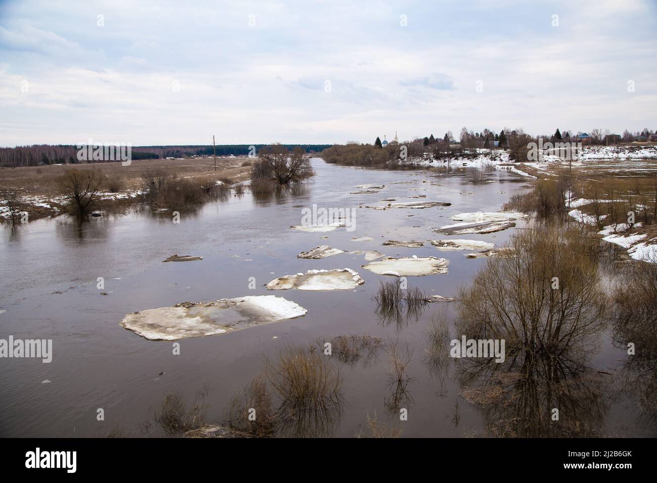 Small white ice floes float down the river slowly. Spring, snow melts ...