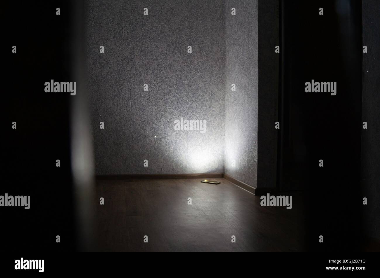 a wall lit by a phone flashlight is reflected in the whole room light ...