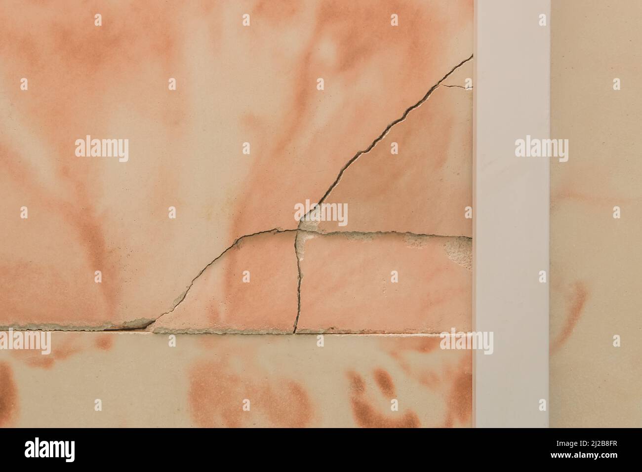 Broken cracked damaged stone tile wall surface in need of repair old ...