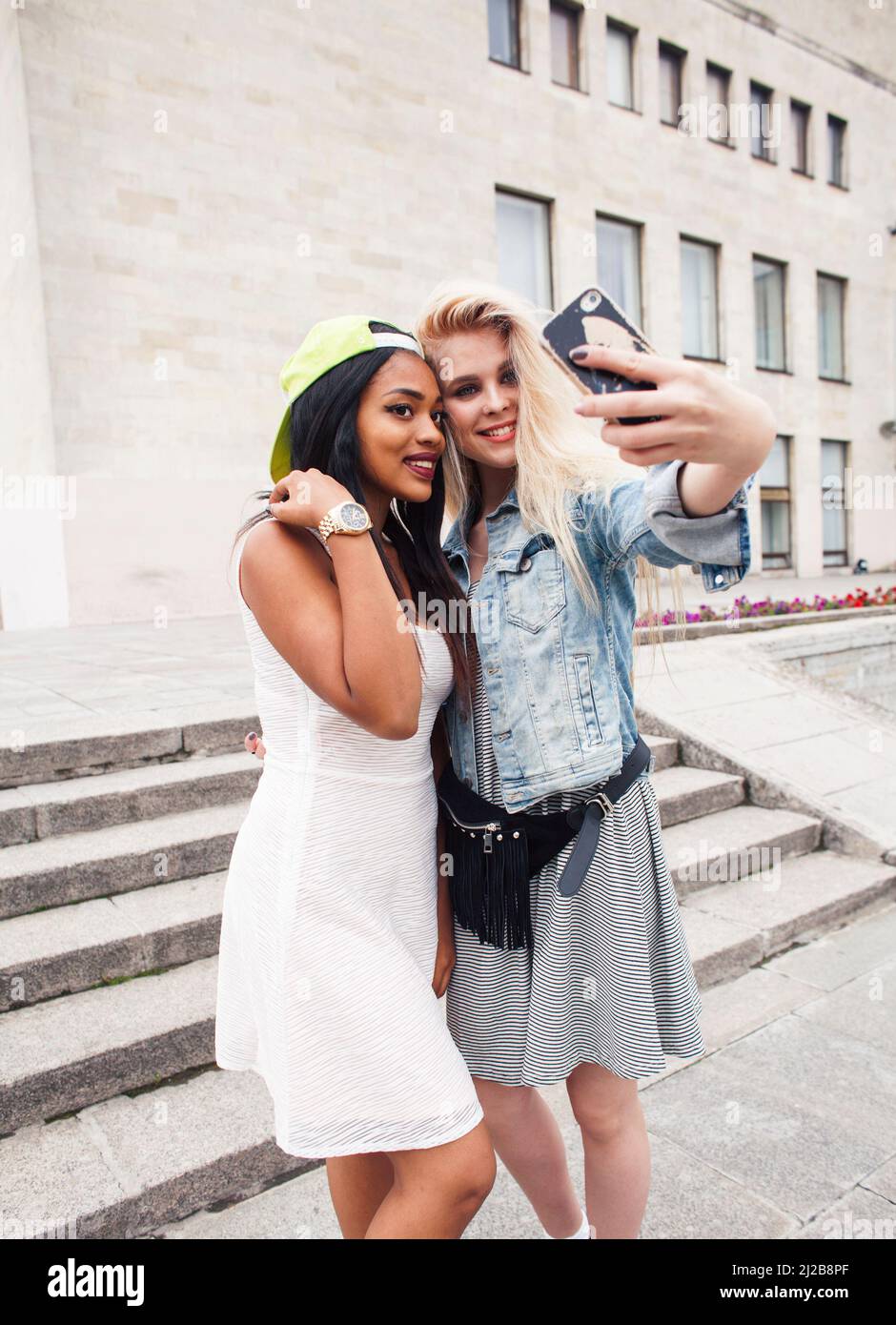 Two teenage diverse nations girls infront of university building ...