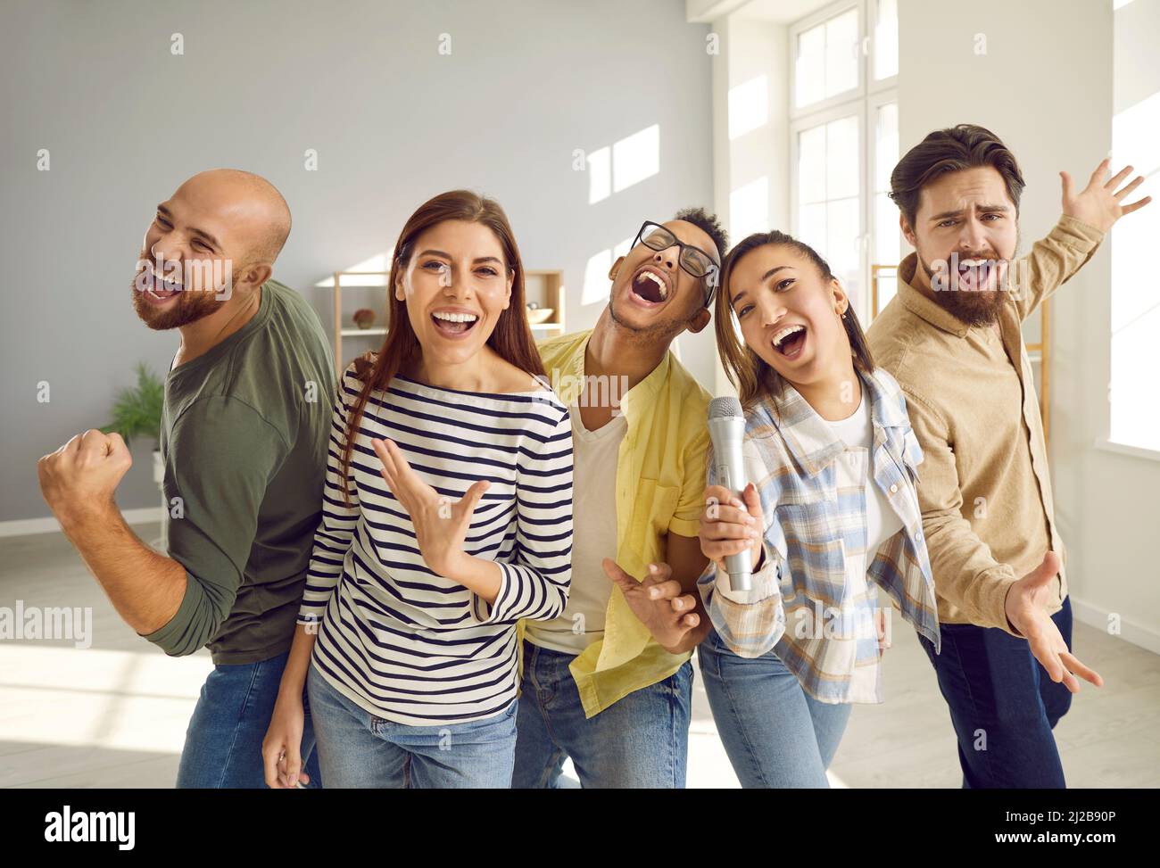 Happy friends singing karaoke party hi-res stock photography and images ...