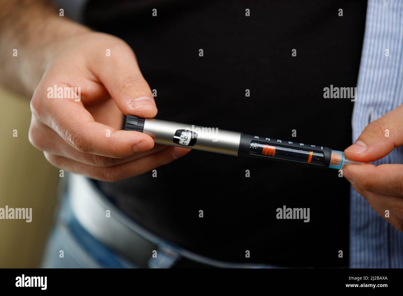 Man holding in two hands a syringe of insulin preparing to make an ...