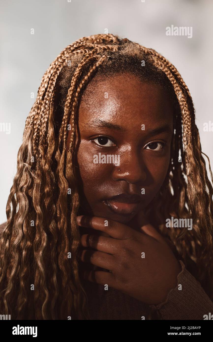 Portrait of young woman with braided hair in studio Stock Photo - Alamy