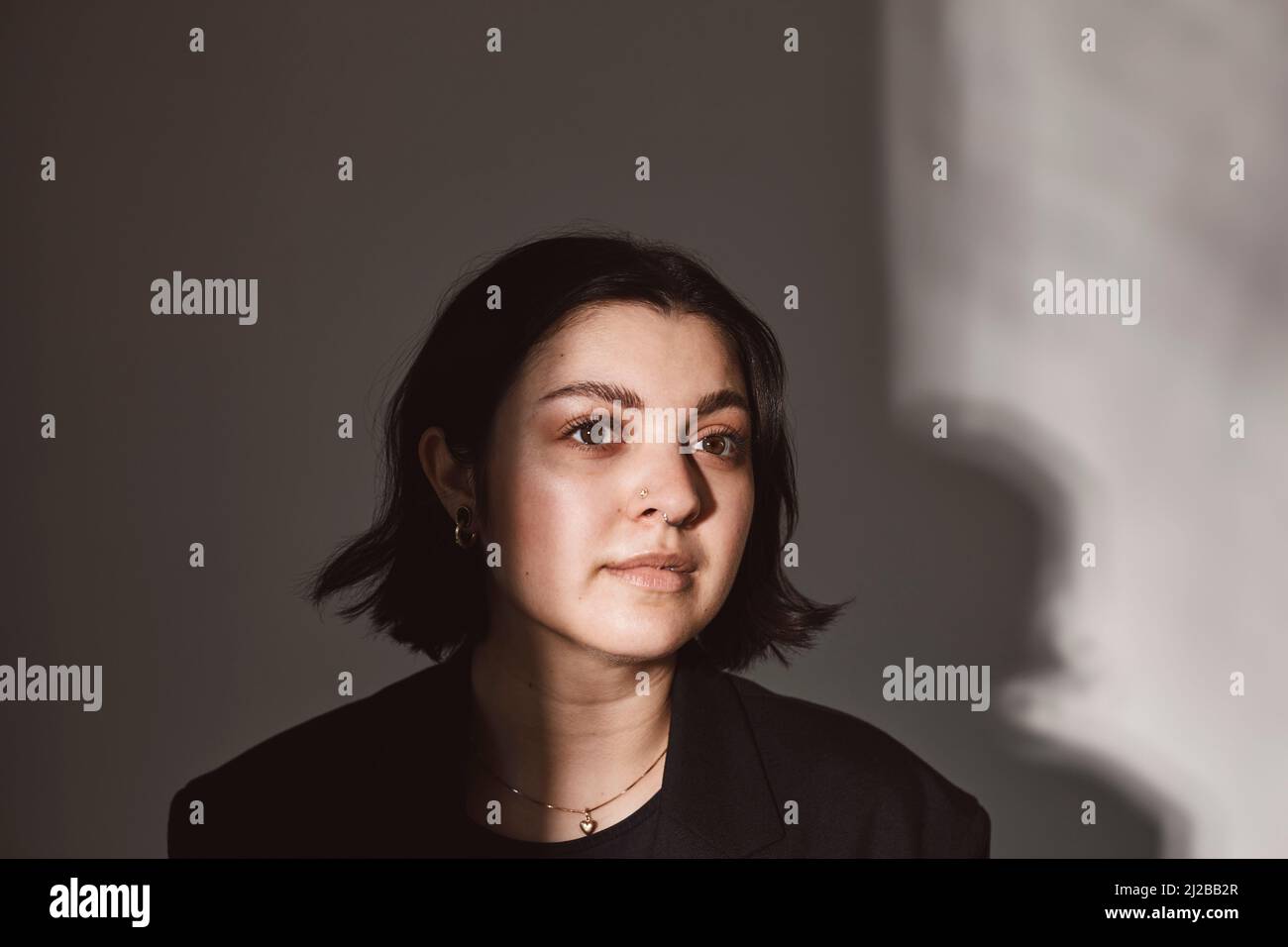 Contemplative young woman looking away against white background Stock ...