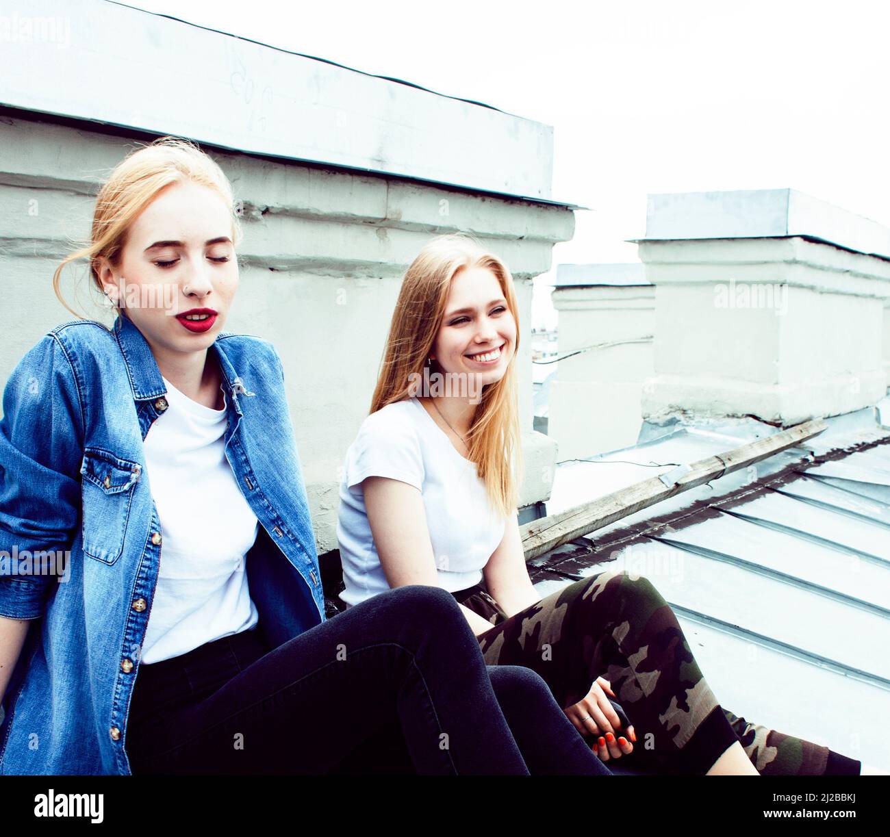 two cool blond real girls friends making selfie on roof top, lifestyle ...