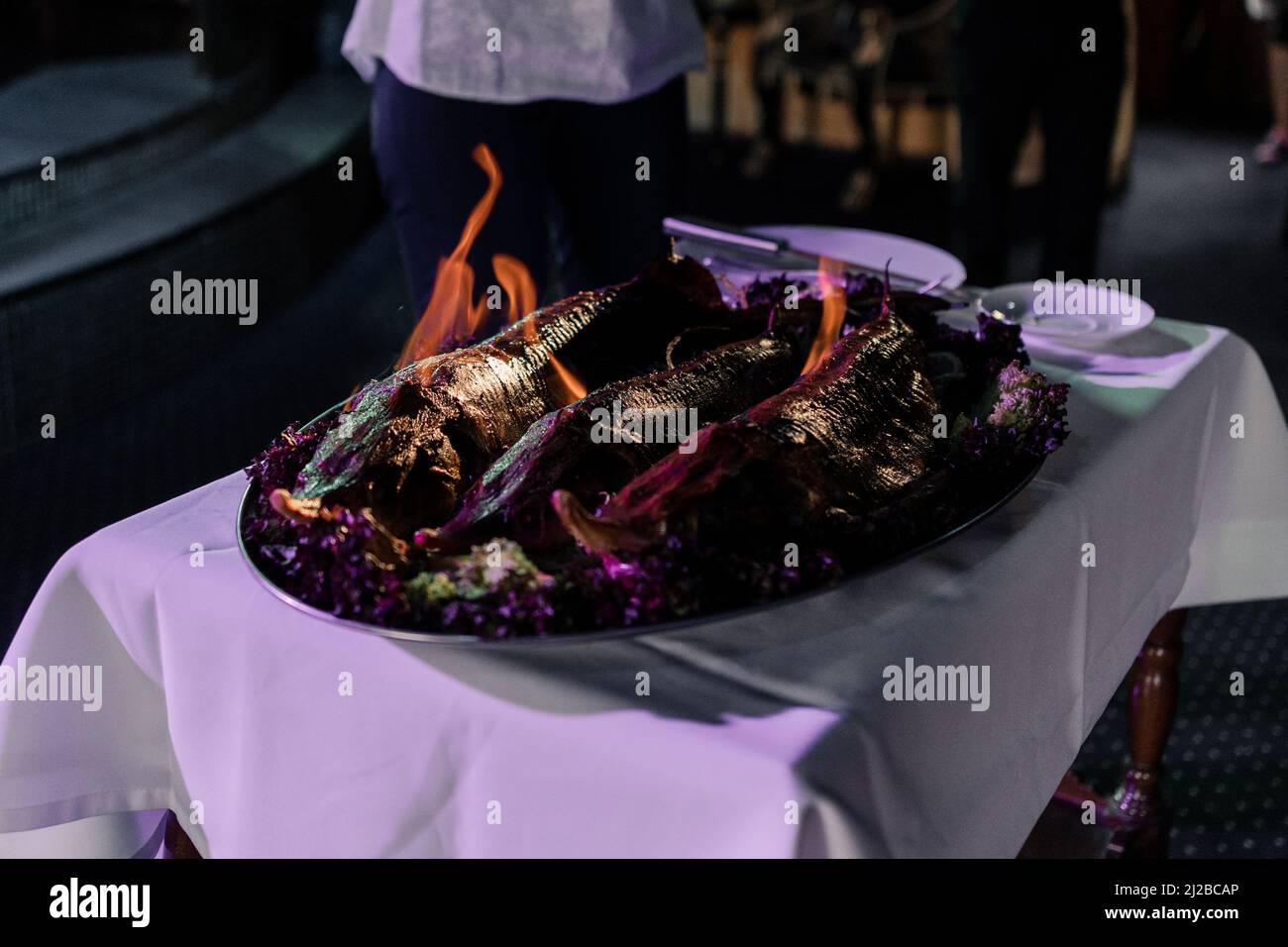 large piece of fried meat on fire at the cook in the restaurant Stock ...