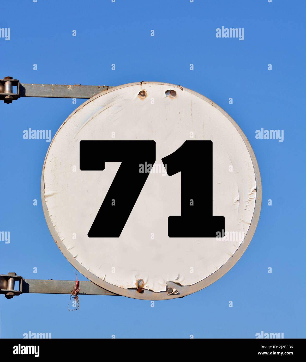 A speed limit sign with number 71 added on it against a blue sky Stock ...