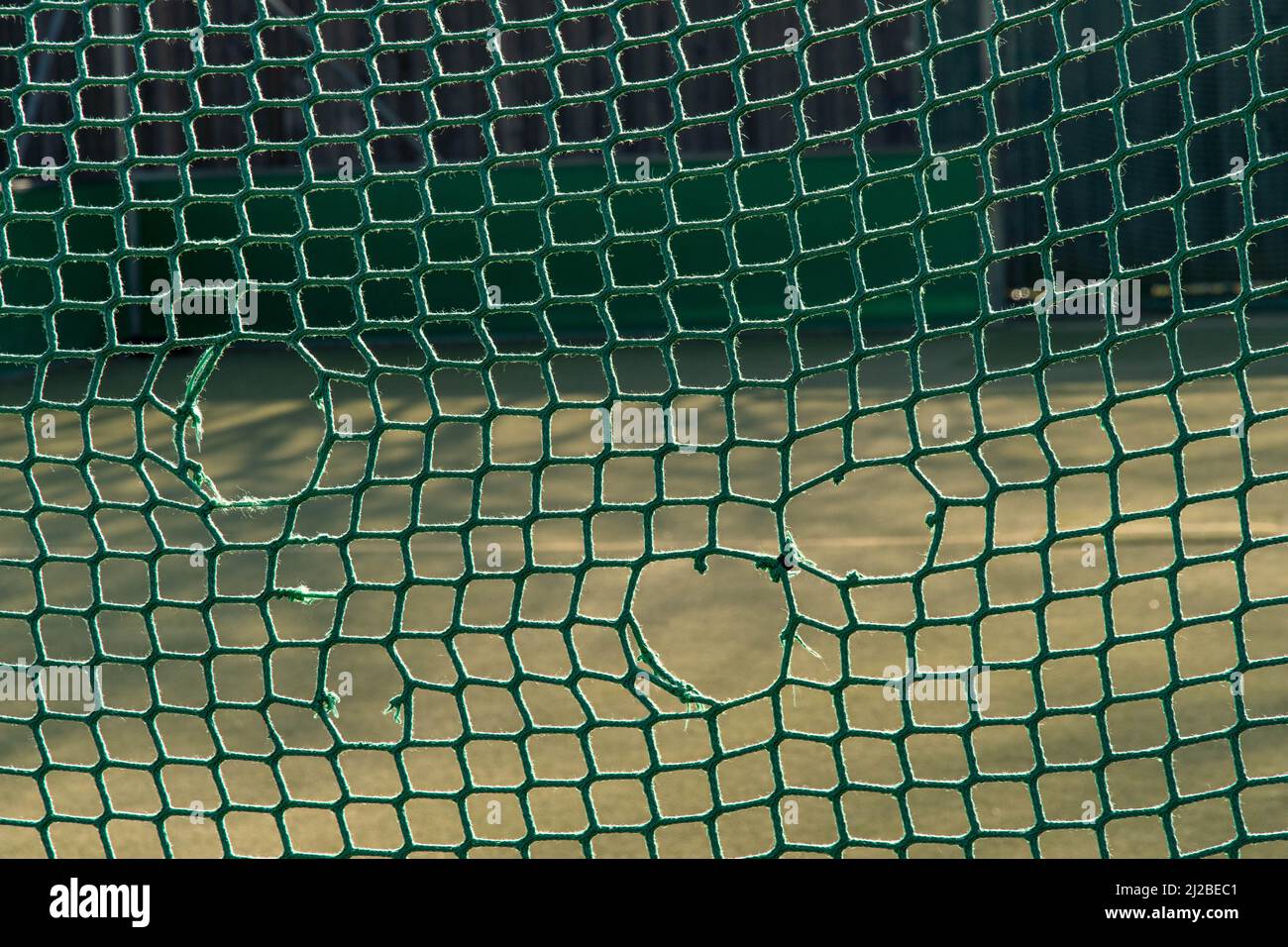 Football net with holes on a playground Stock Photo - Alamy