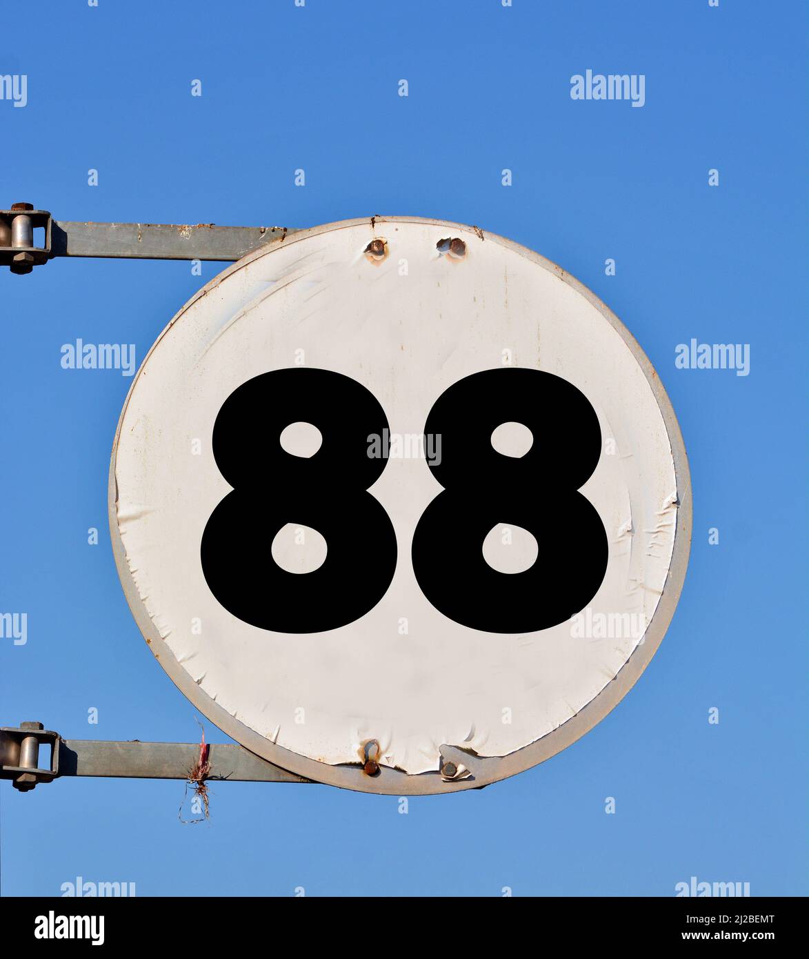 A speed limit sign with number 88 added on it against a blue sky Stock ...