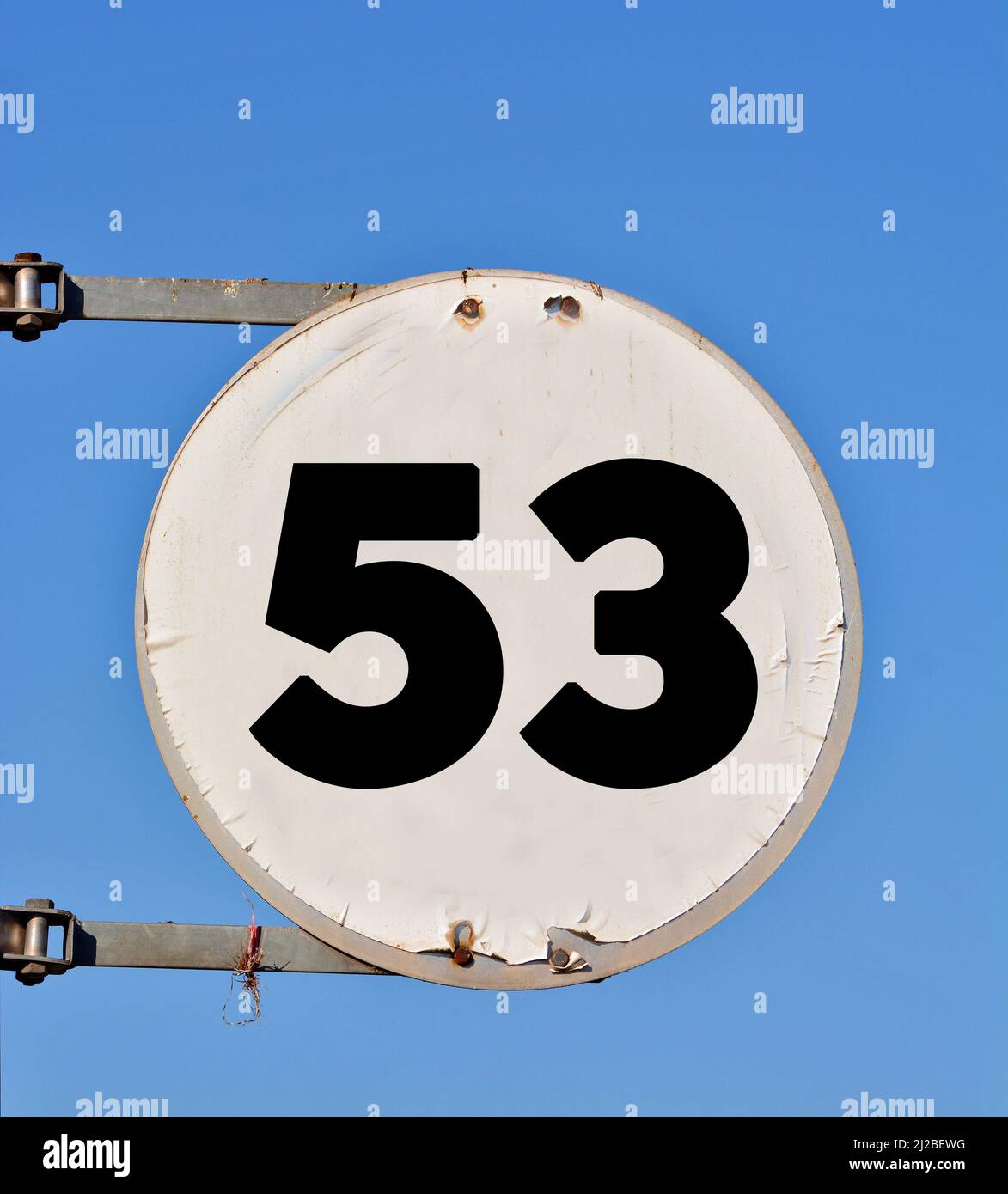 A speed limit sign with number 53 added on it against a blue sky Stock ...