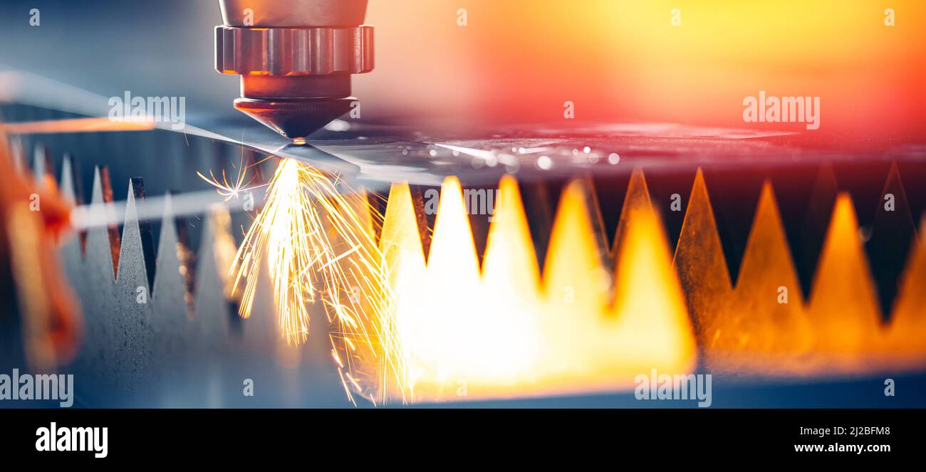 Macro CNC laser machine cutting sheet metal with light spark ...